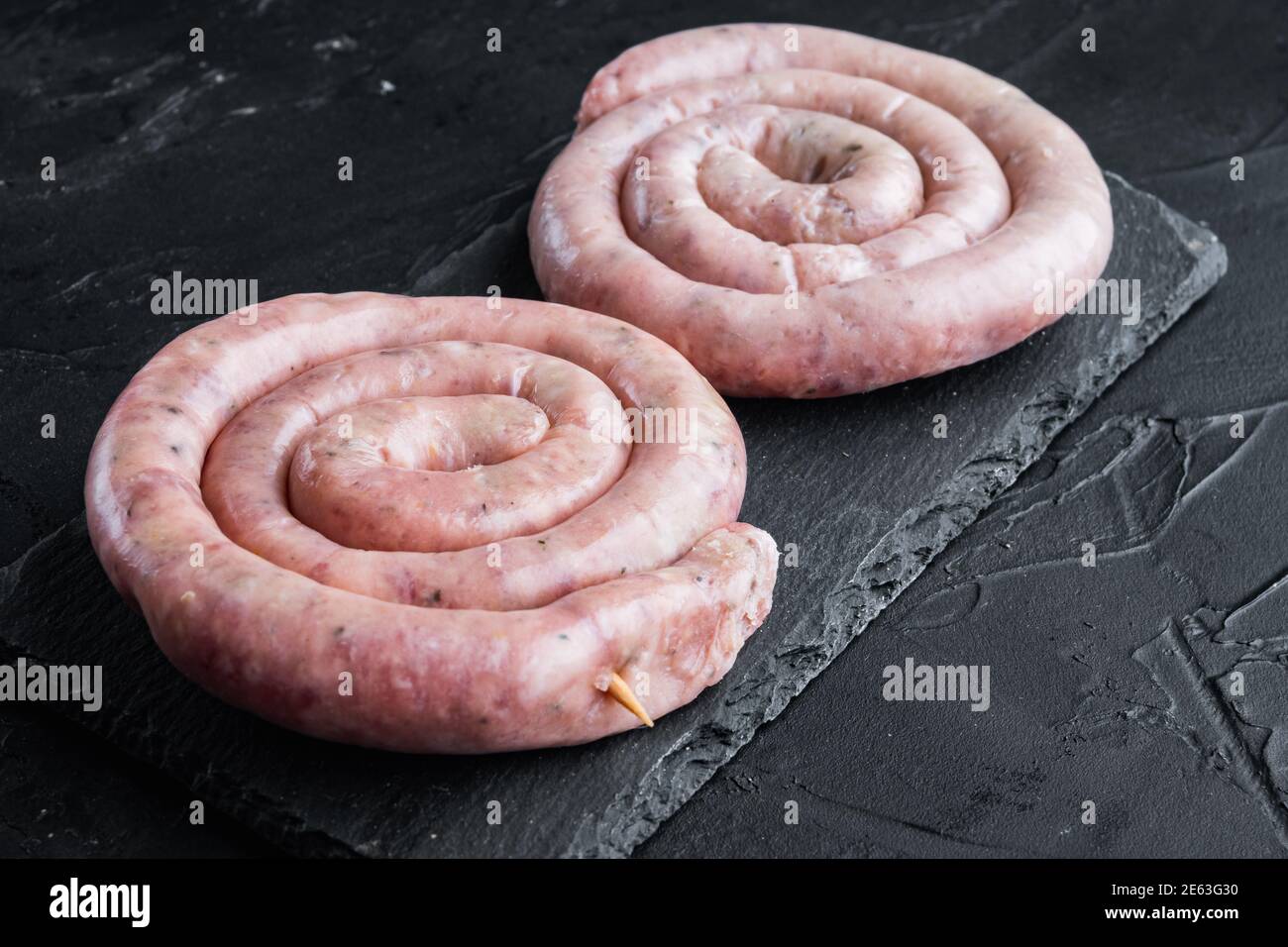 Raw snail sausage in traditional spiral set, on black background Stock ...