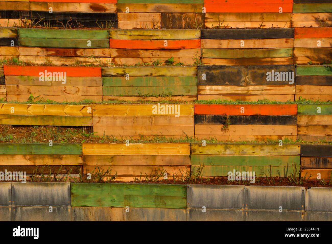 Wall of brightly painted wooden planks used to support planters for ...