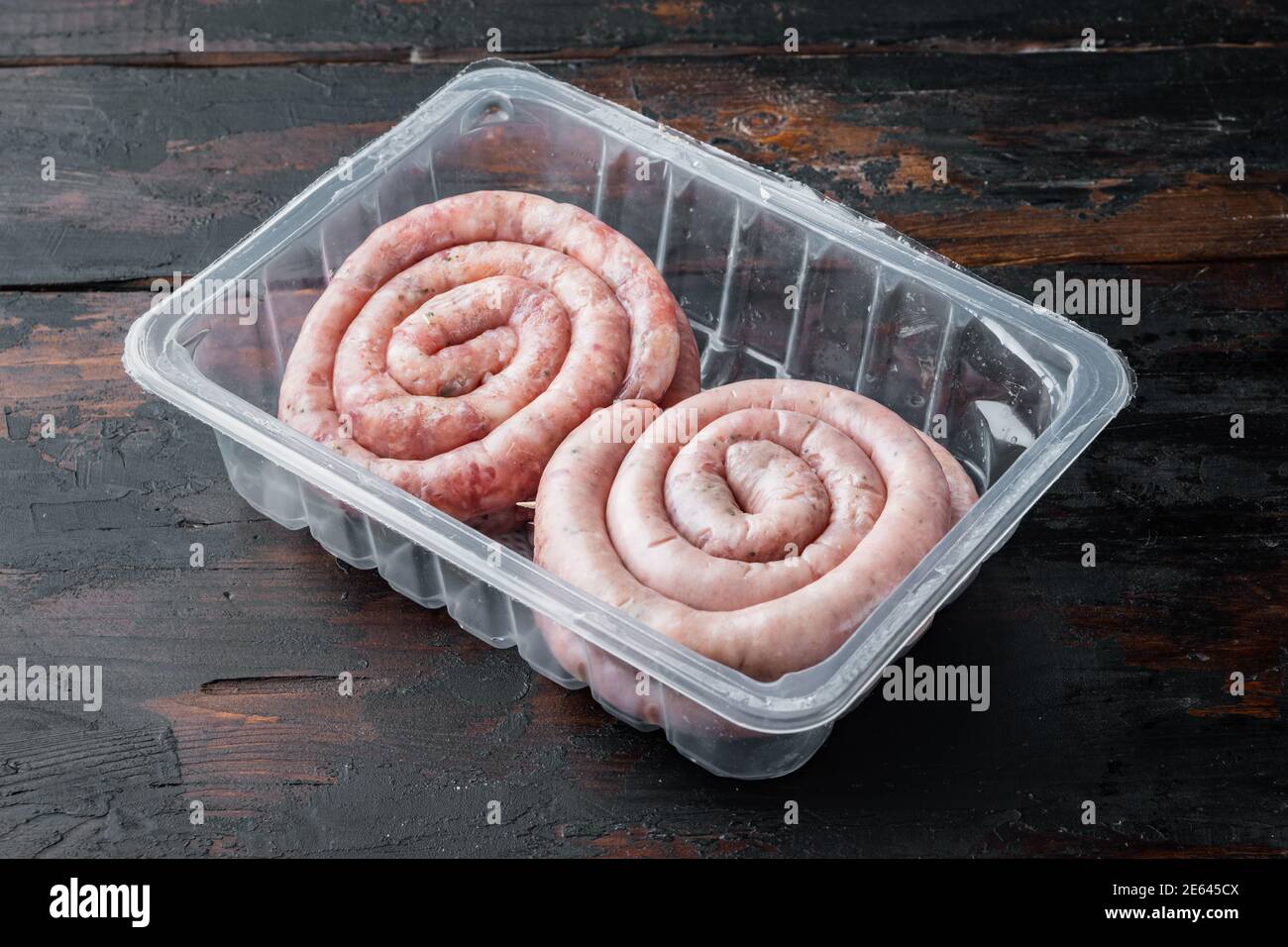 Raw snail sausage in traditional spiral set, on old dark wooden table ...