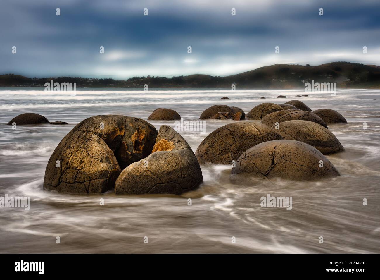The iconic famous huge round boulders sitting on Moeraki beach with the ...