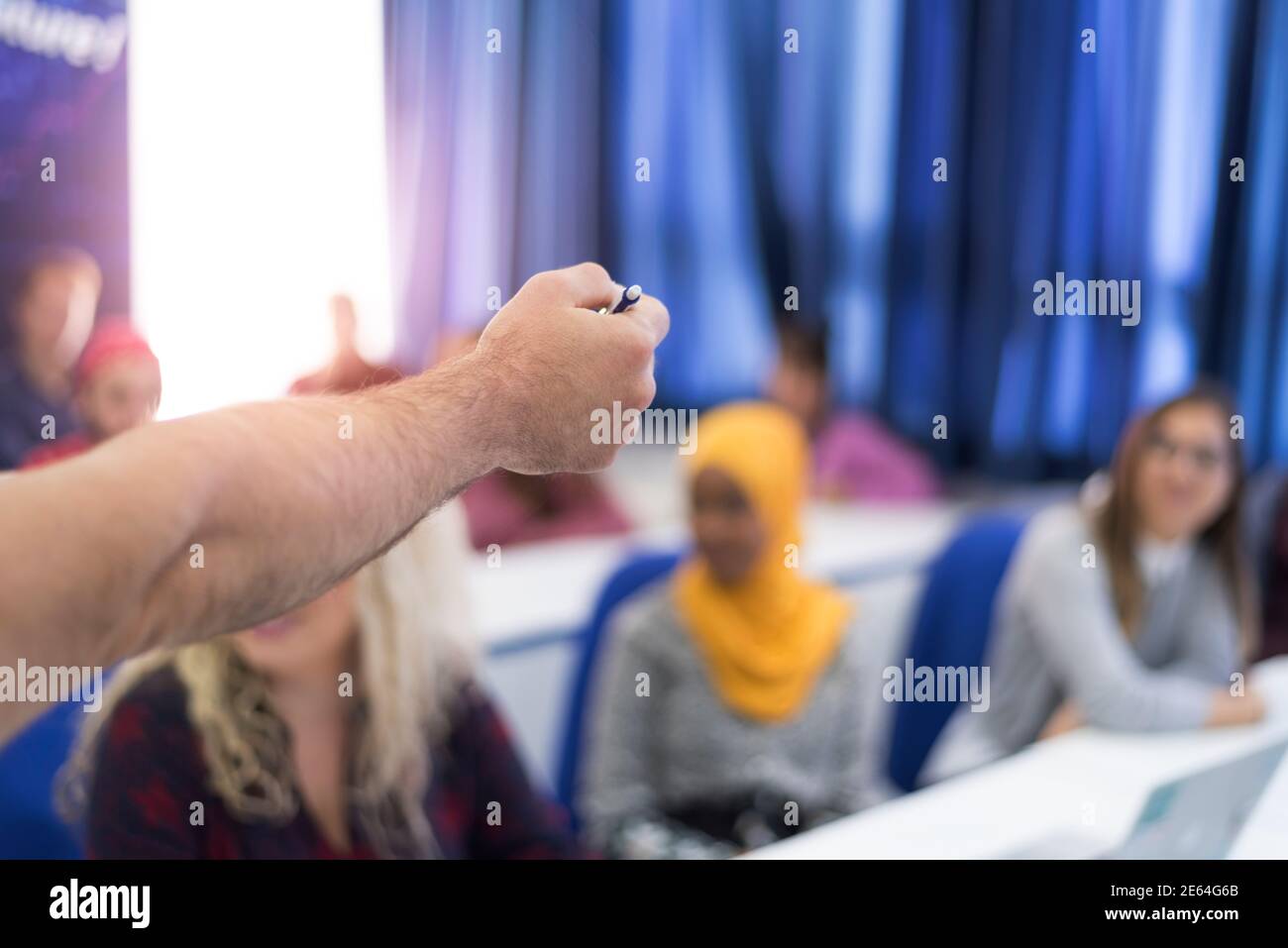 University students in the classroom with a teacher explaining them ...
