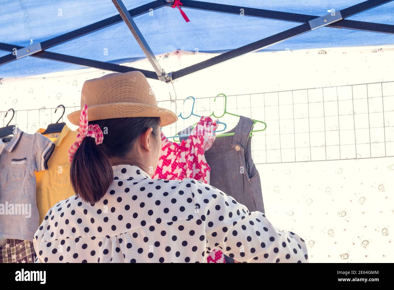 Female owner of a small clothing store arranging products for customers ...