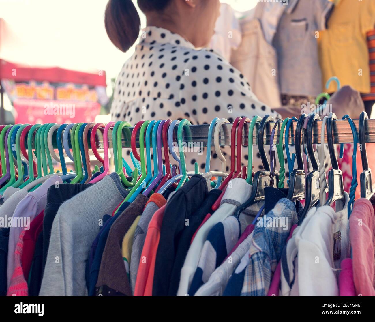 Female owner of a small clothing store arranging products for customers ...