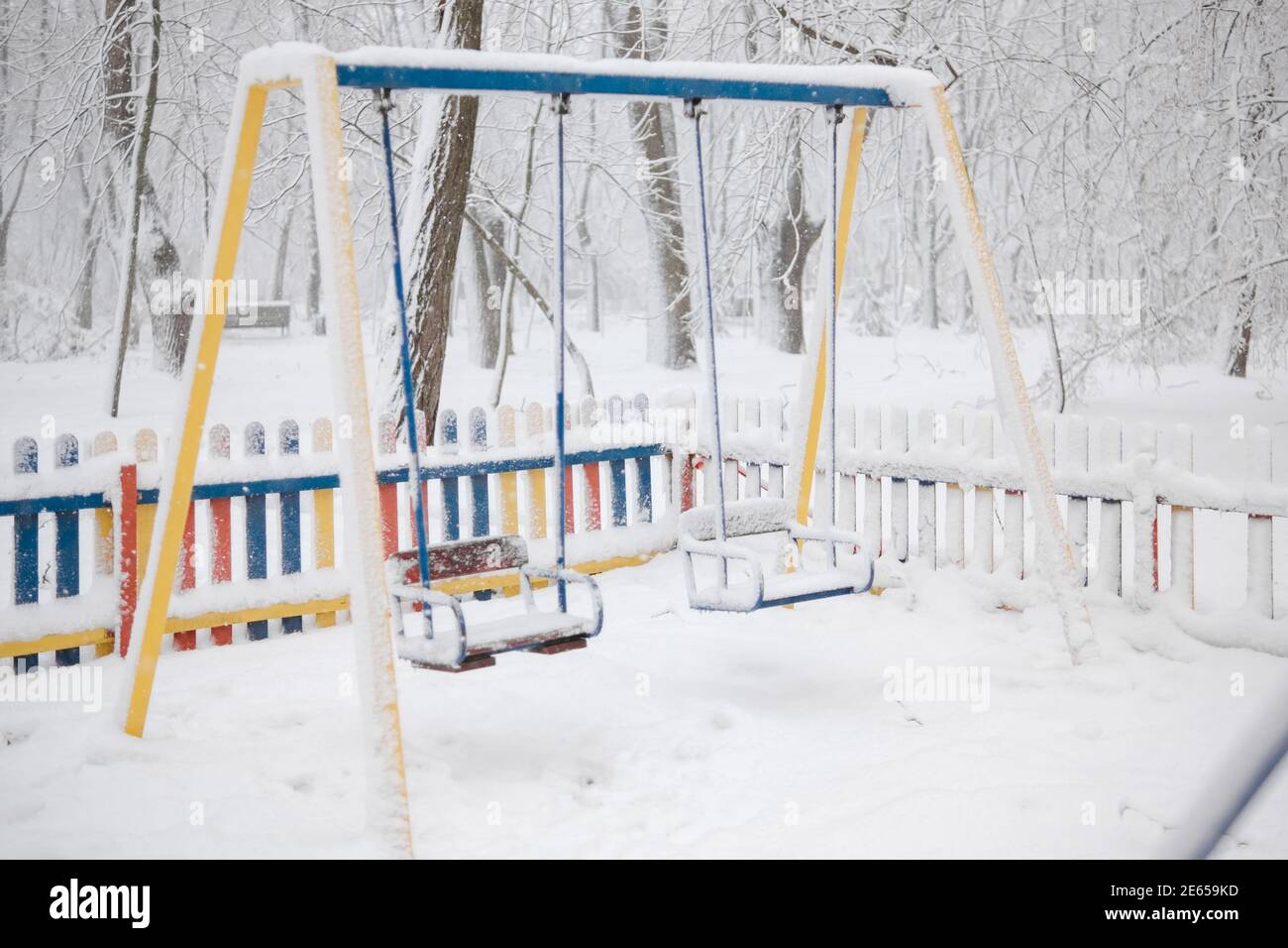 Snow-covered multi-colored fence made of wood. Severe frost, the ...