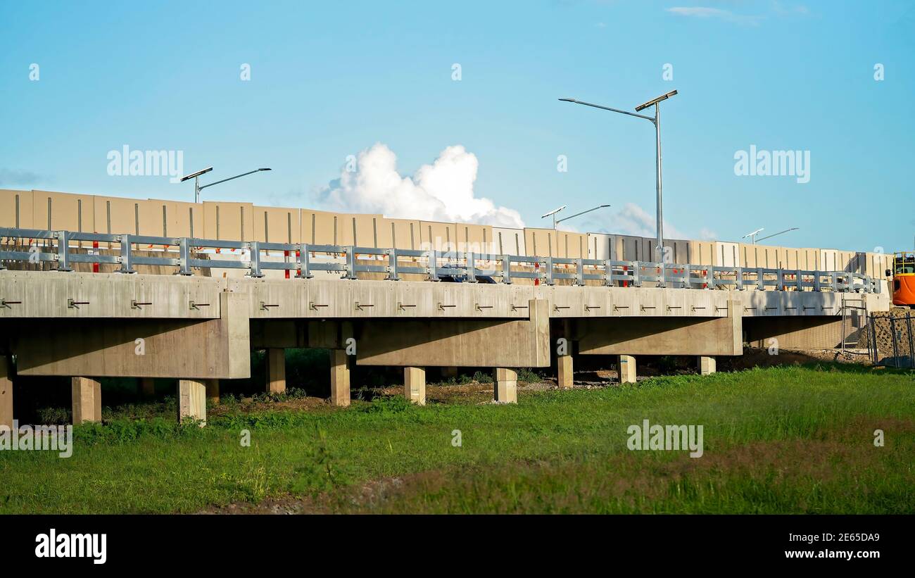 A concrete bridge highway overpass across a creek, parts of which are ...