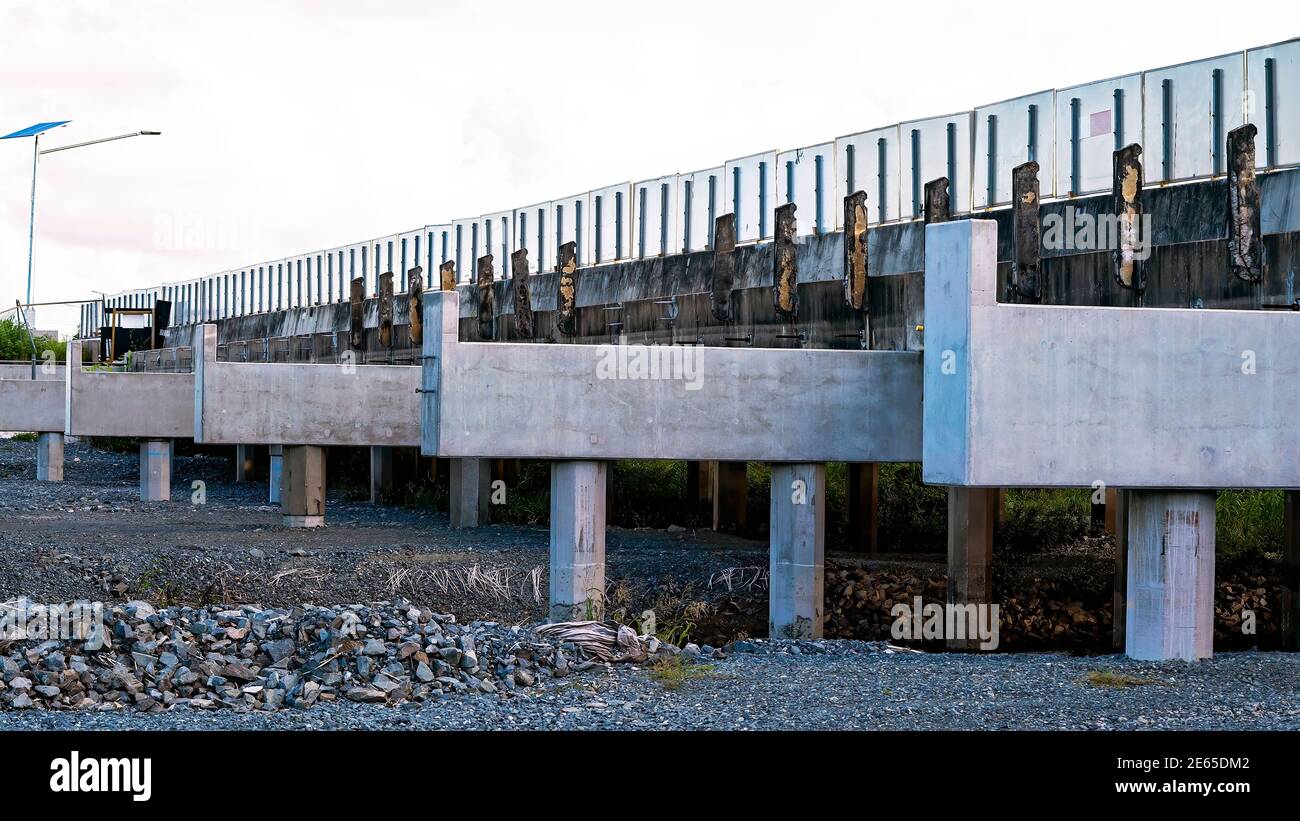 A concrete bridge highway overpass across a creek, parts of which are ...
