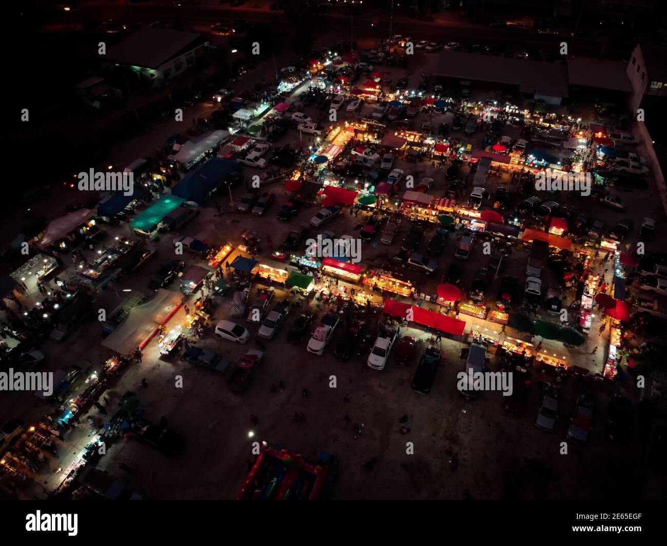 Aerial view at night market. There are many people, cars and shops ...