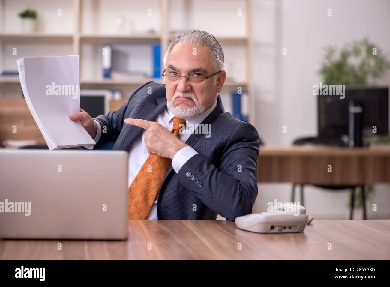 Old employee working in the office Stock Photo - Alamy