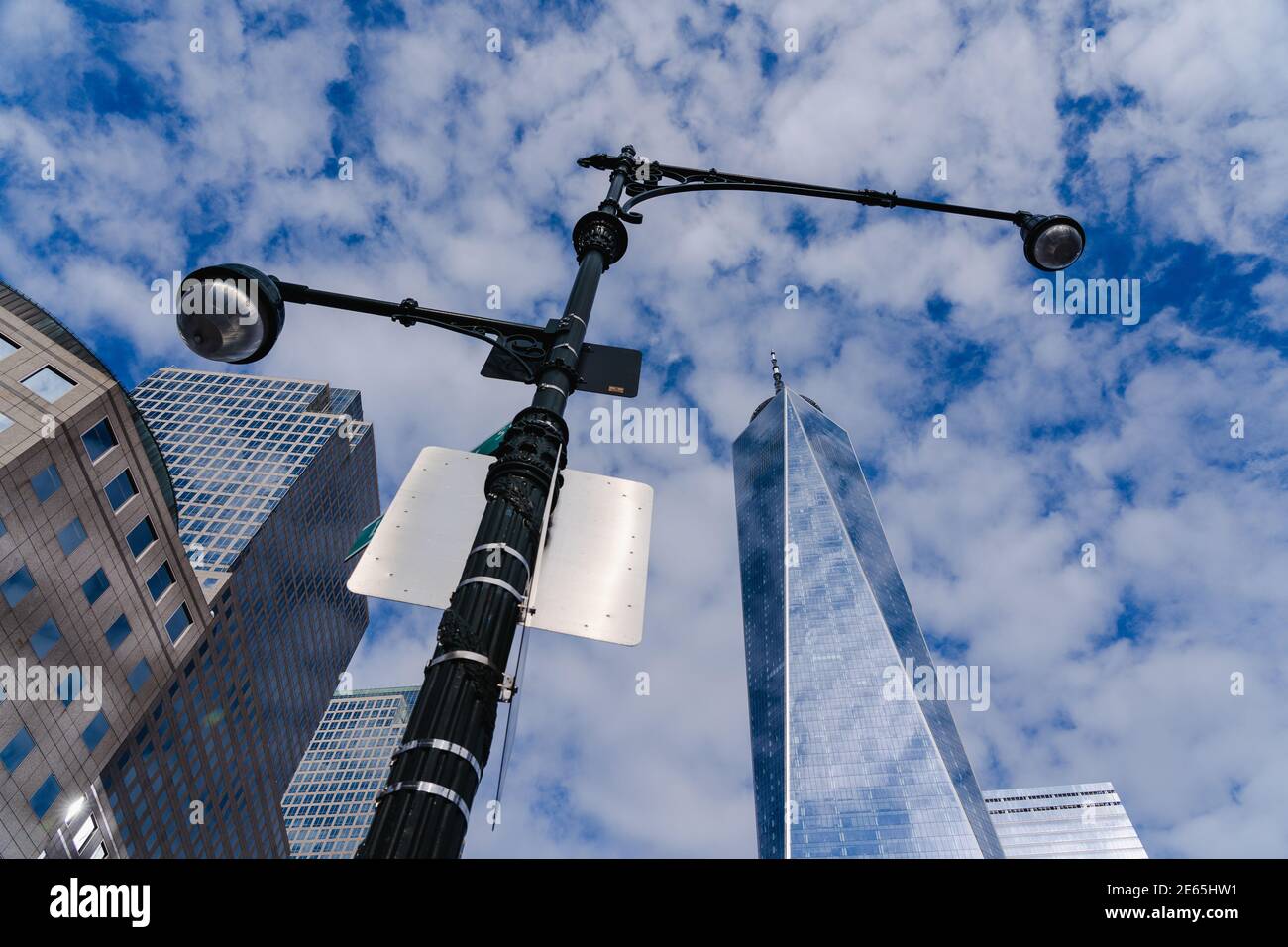 View looking up at the sky with a tall lamp post in the center of frame ...