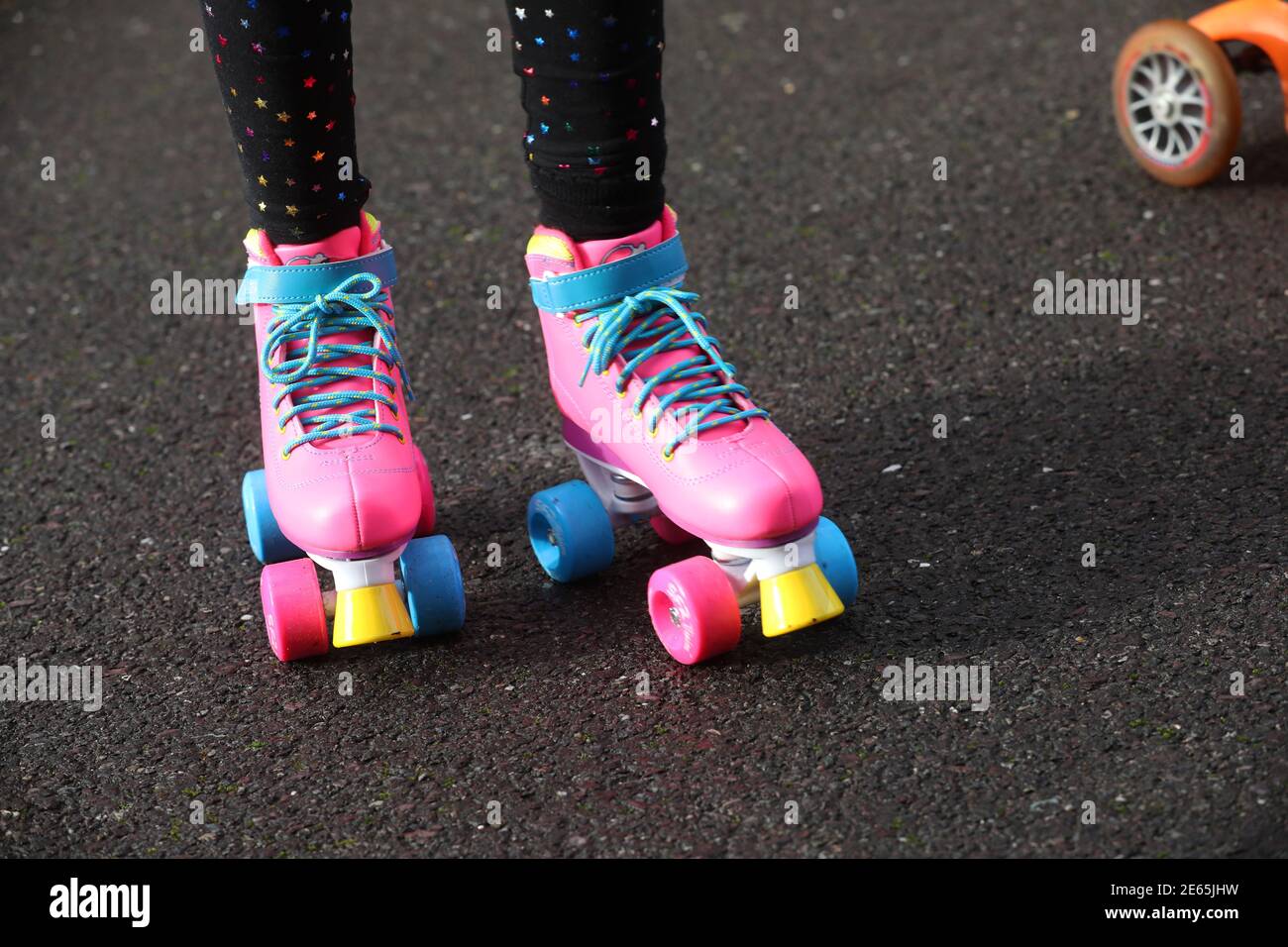 A young girl wearing bright pink roller boots in Sussex, UK Stock Photo ...