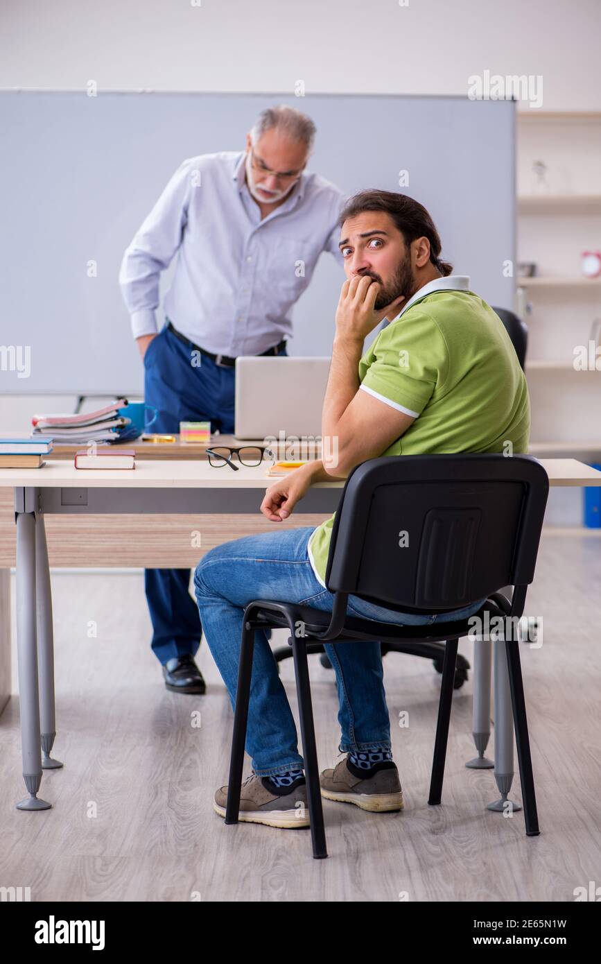 Aged male teacher and young male student in the classroom Stock Photo ...