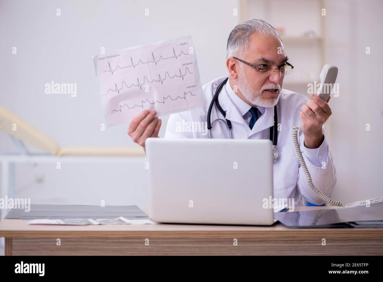 Old male doctor cardiologist working in the hospital Stock Photo - Alamy