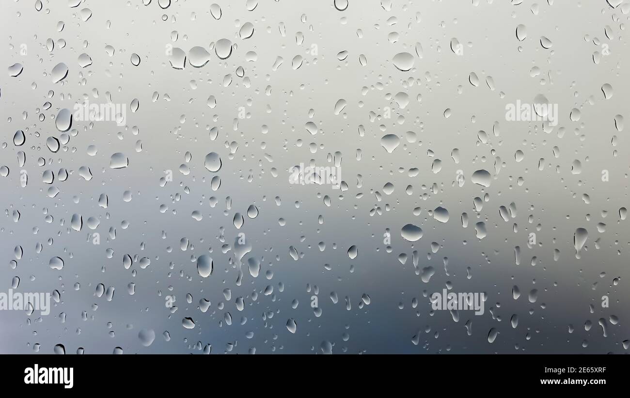 Rain drops running down a window in a close up view Stock Photo - Alamy