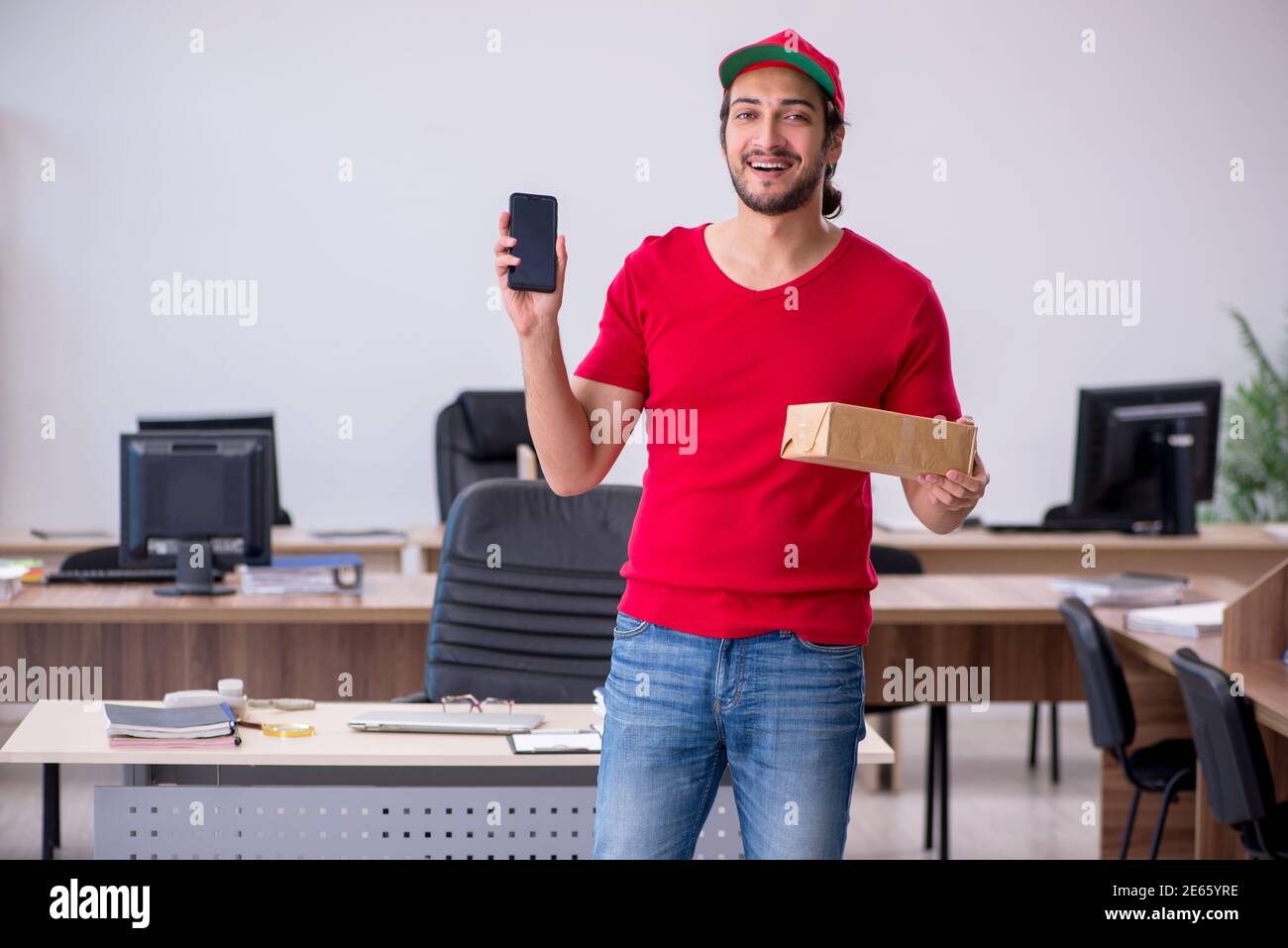 Young courier delivering post to the office Stock Photo - Alamy