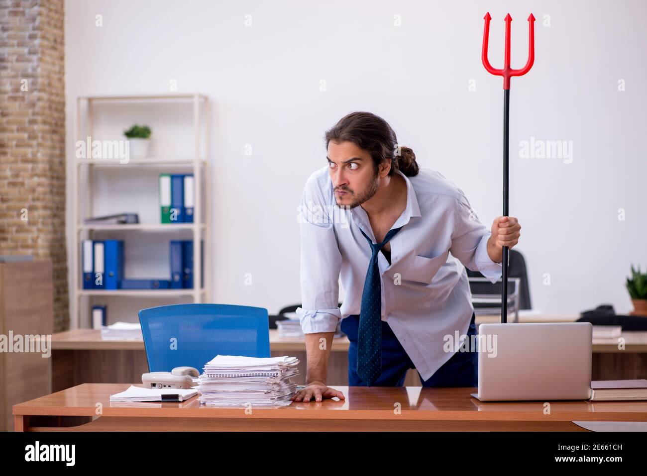 Devil businessman holding trident in the office Stock Photo - Alamy