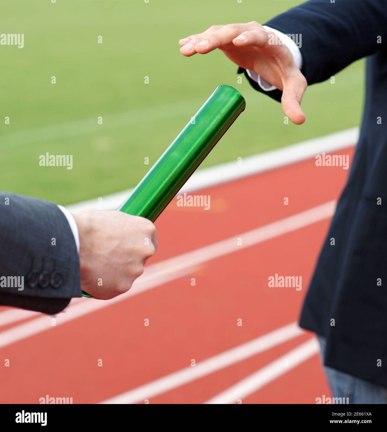 Businessmen pass on the baton in relay race in stadium Stock Photo - Alamy