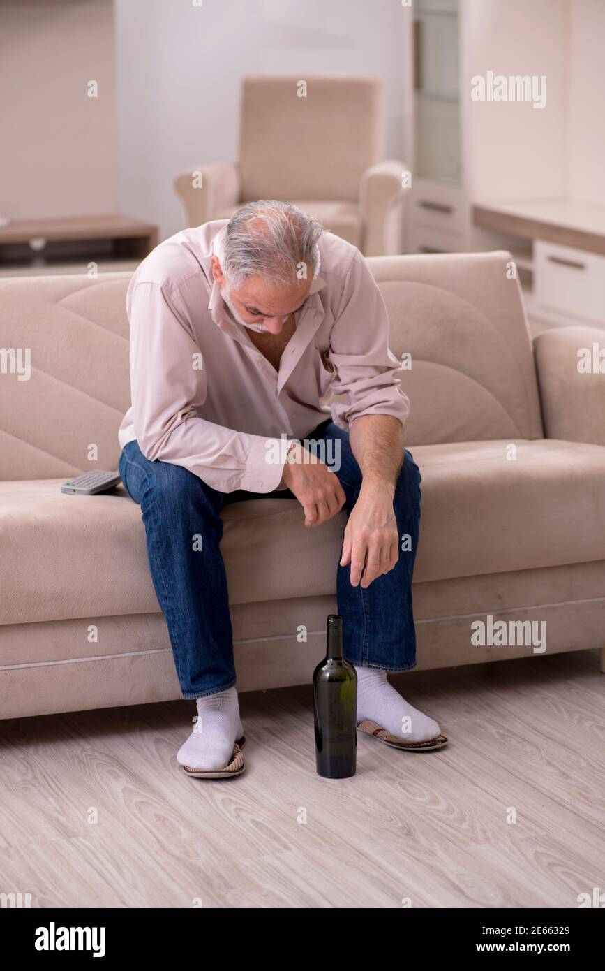 Aged man drinking alcohol at home Stock Photo - Alamy