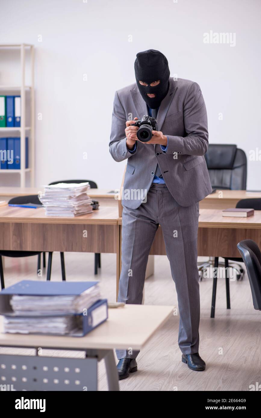 Young employee in industrial espionage concept Stock Photo - Alamy