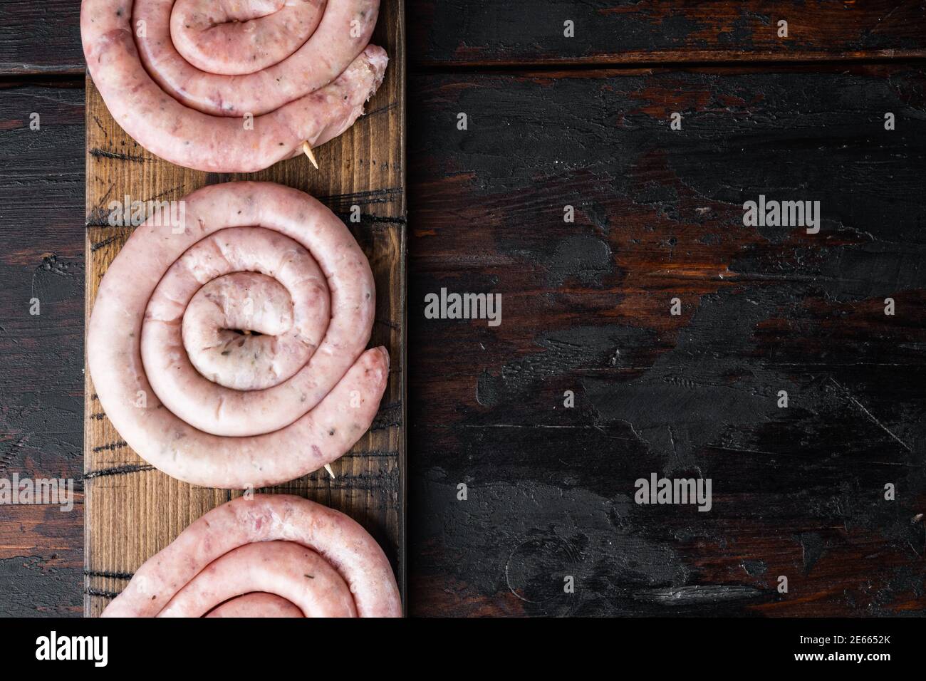 Raw snail sausage in traditional spiral set, on old dark wooden table ...