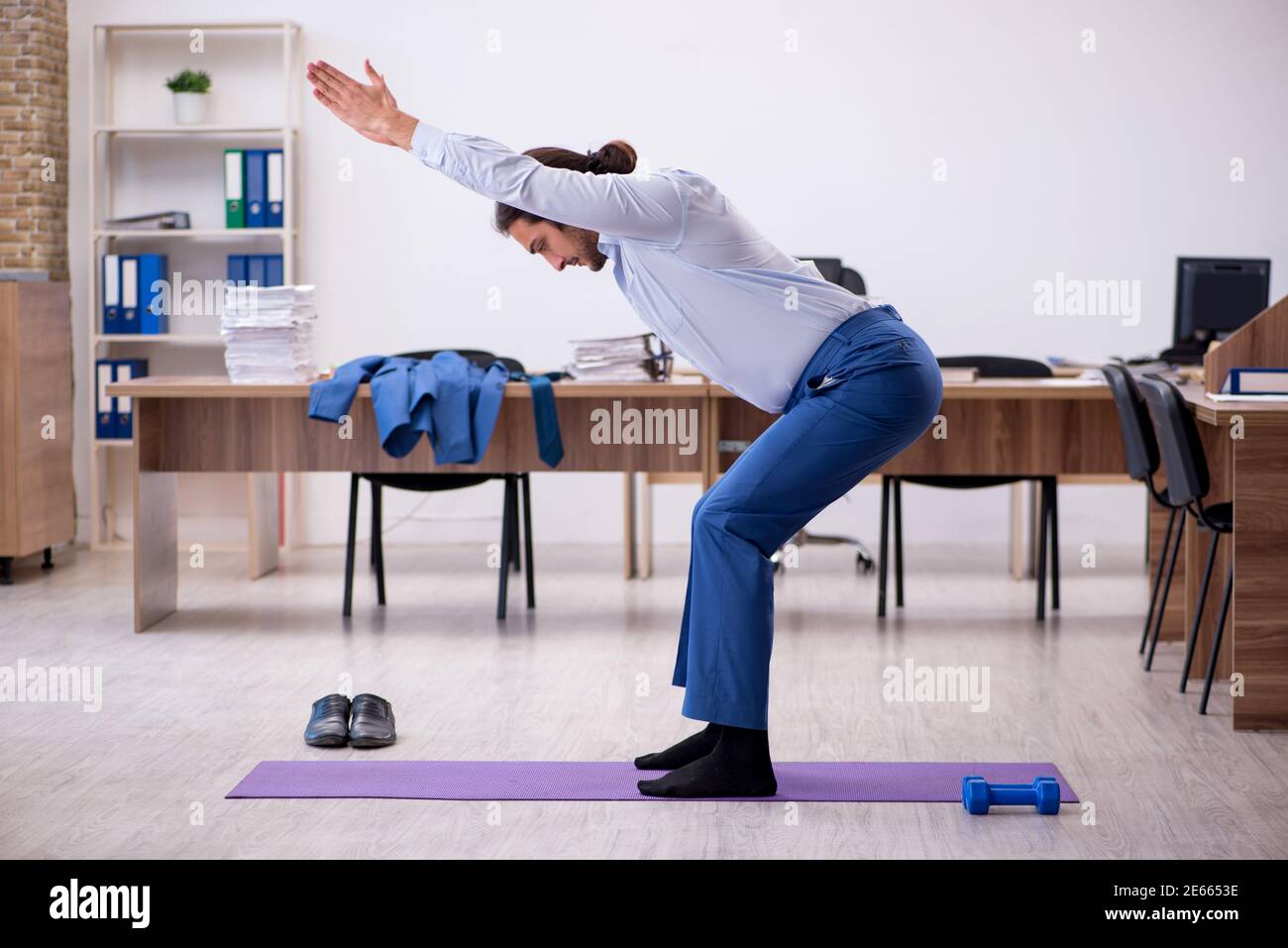 Young employee doing sport exercises during break Stock Photo - Alamy
