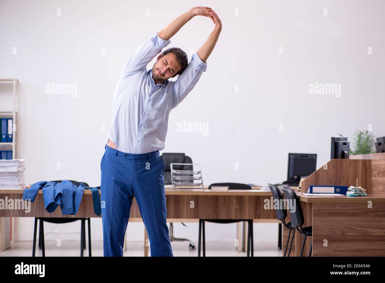 Young employee doing sport exercises during break Stock Photo - Alamy