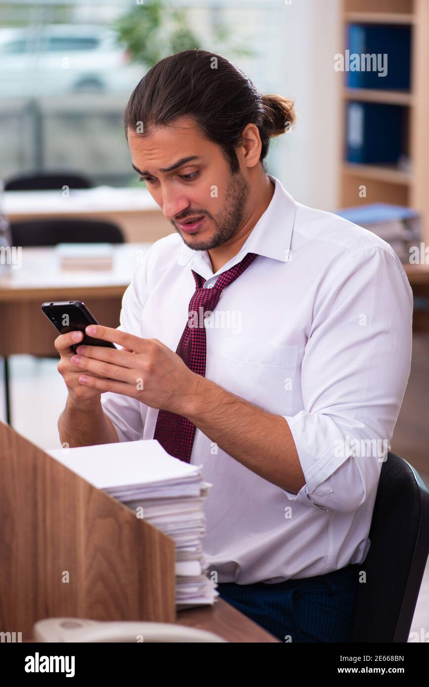 Young employee and too many work in the office Stock Photo - Alamy