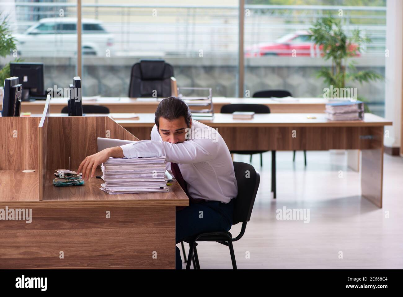 Young employee and too many work in the office Stock Photo - Alamy
