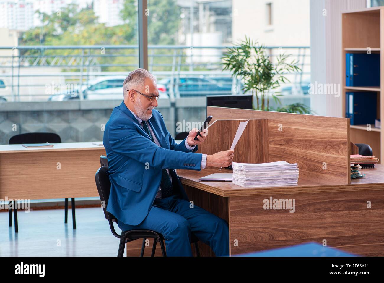Old employee working in the office Stock Photo - Alamy