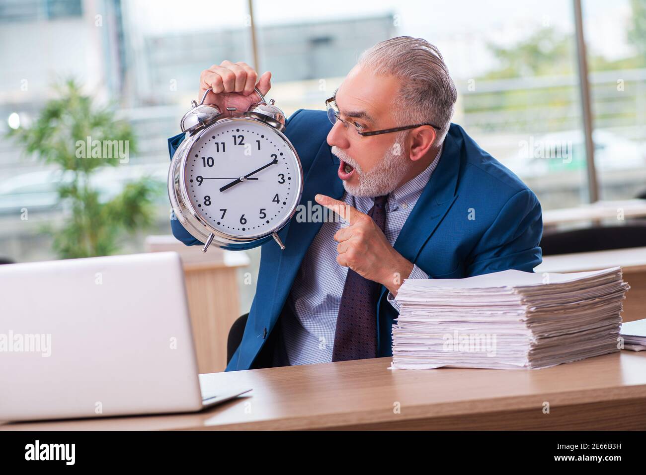 Old boss employee in time management concept Stock Photo - Alamy