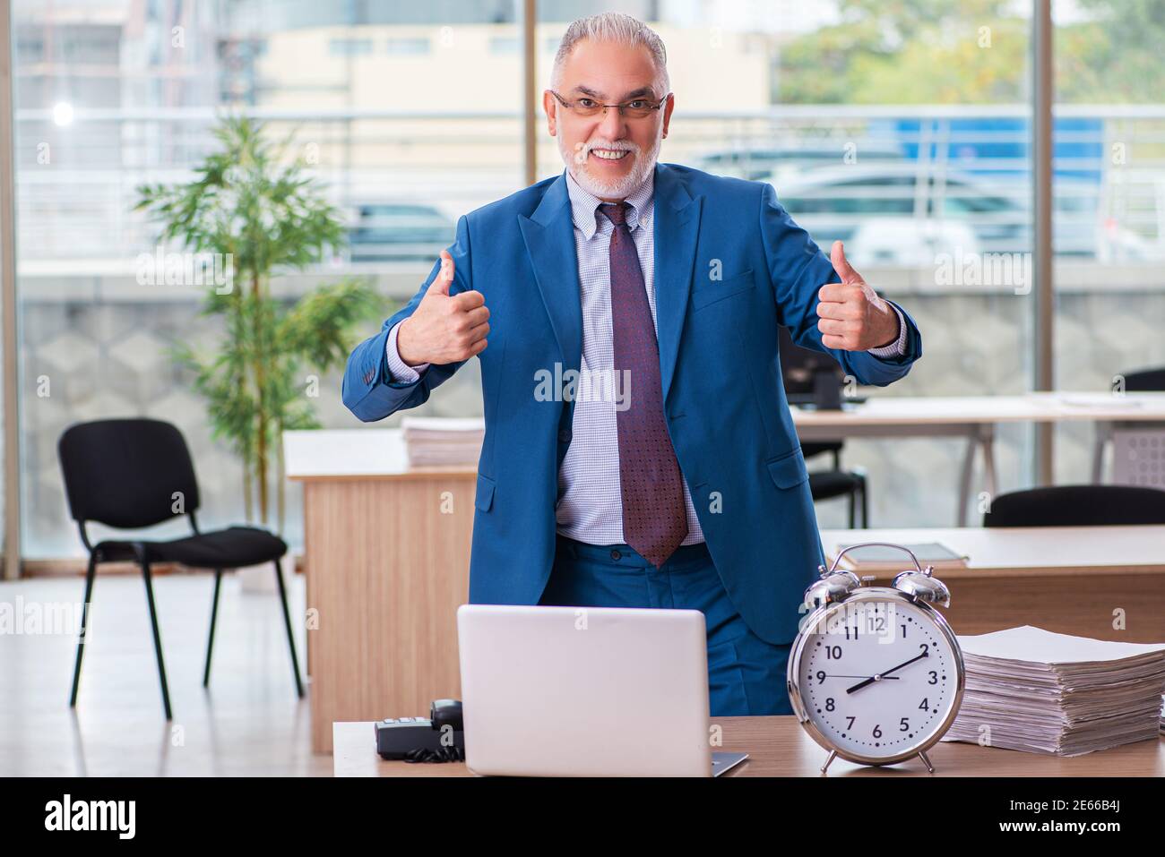 Old boss employee in time management concept Stock Photo - Alamy