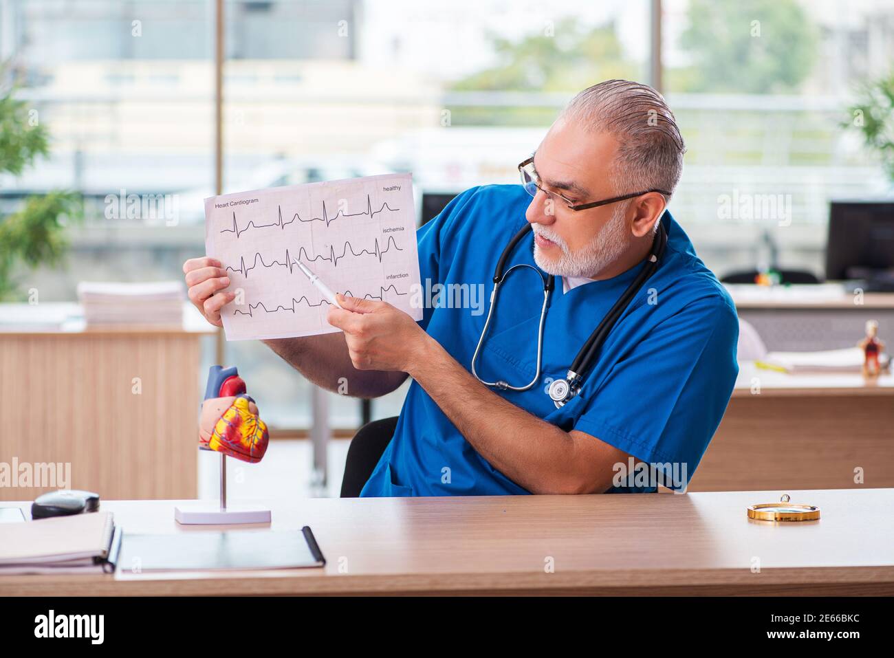 Old doctor cardiologist working in the clinic Stock Photo - Alamy