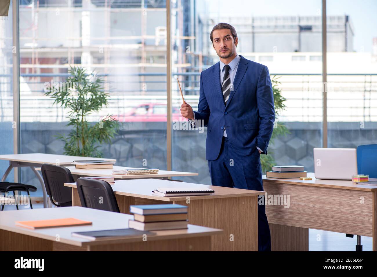 Young teacher in suit in the classroom Stock Photo - Alamy