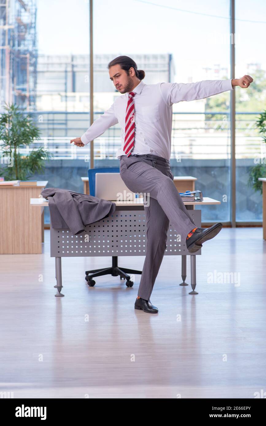 Young employee doing sport exercises at workplace Stock Photo - Alamy