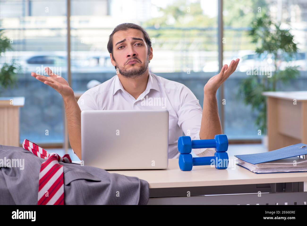 Young employee doing sport exercises at workplace Stock Photo - Alamy