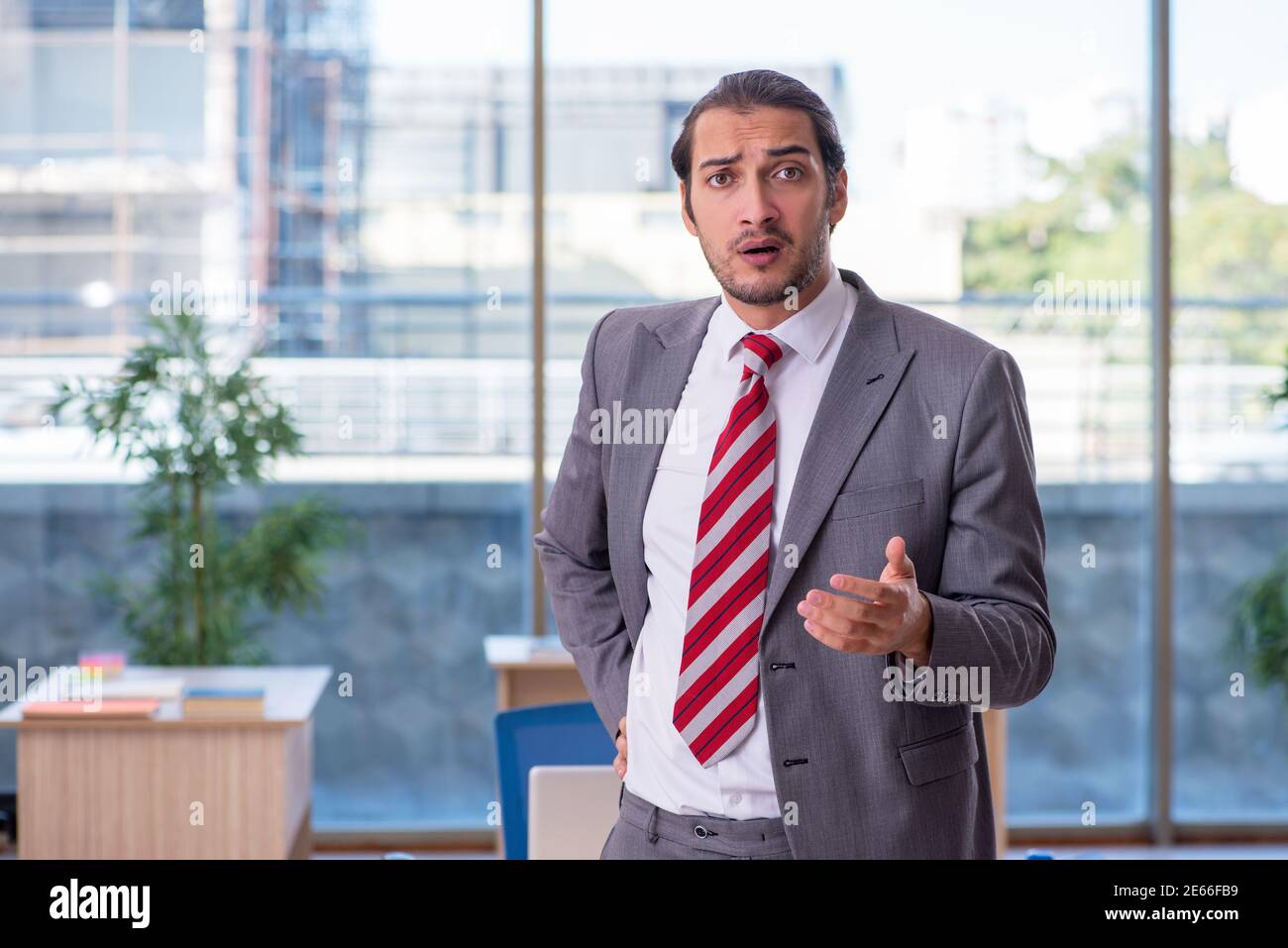 Young employee doing sport exercises at workplace Stock Photo - Alamy