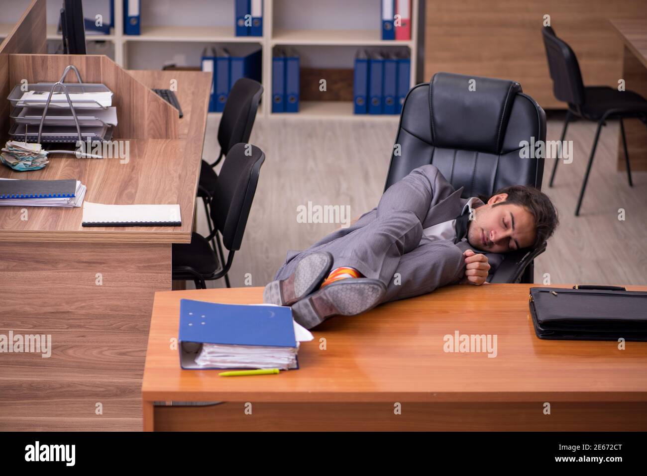 Young employee sleeping at workplace Stock Photo - Alamy