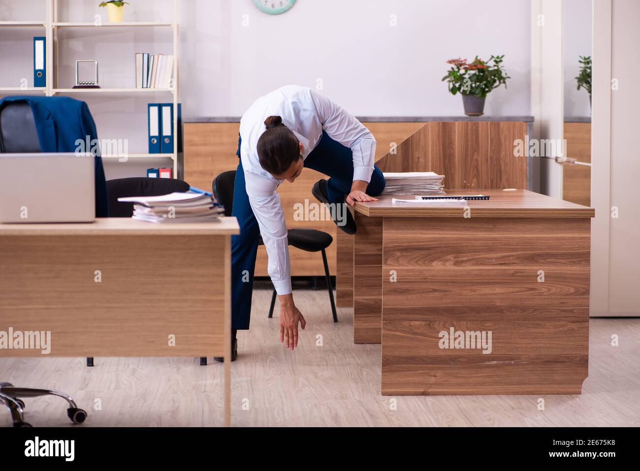 Young employee doing physical exercises at workplace Stock Photo - Alamy