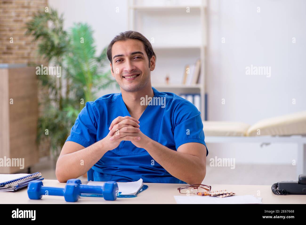 Young doctor physiotherapist doing sport exercises Stock Photo - Alamy