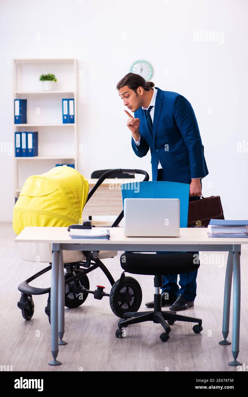 Young employee looking after kid at workplace Stock Photo - Alamy
