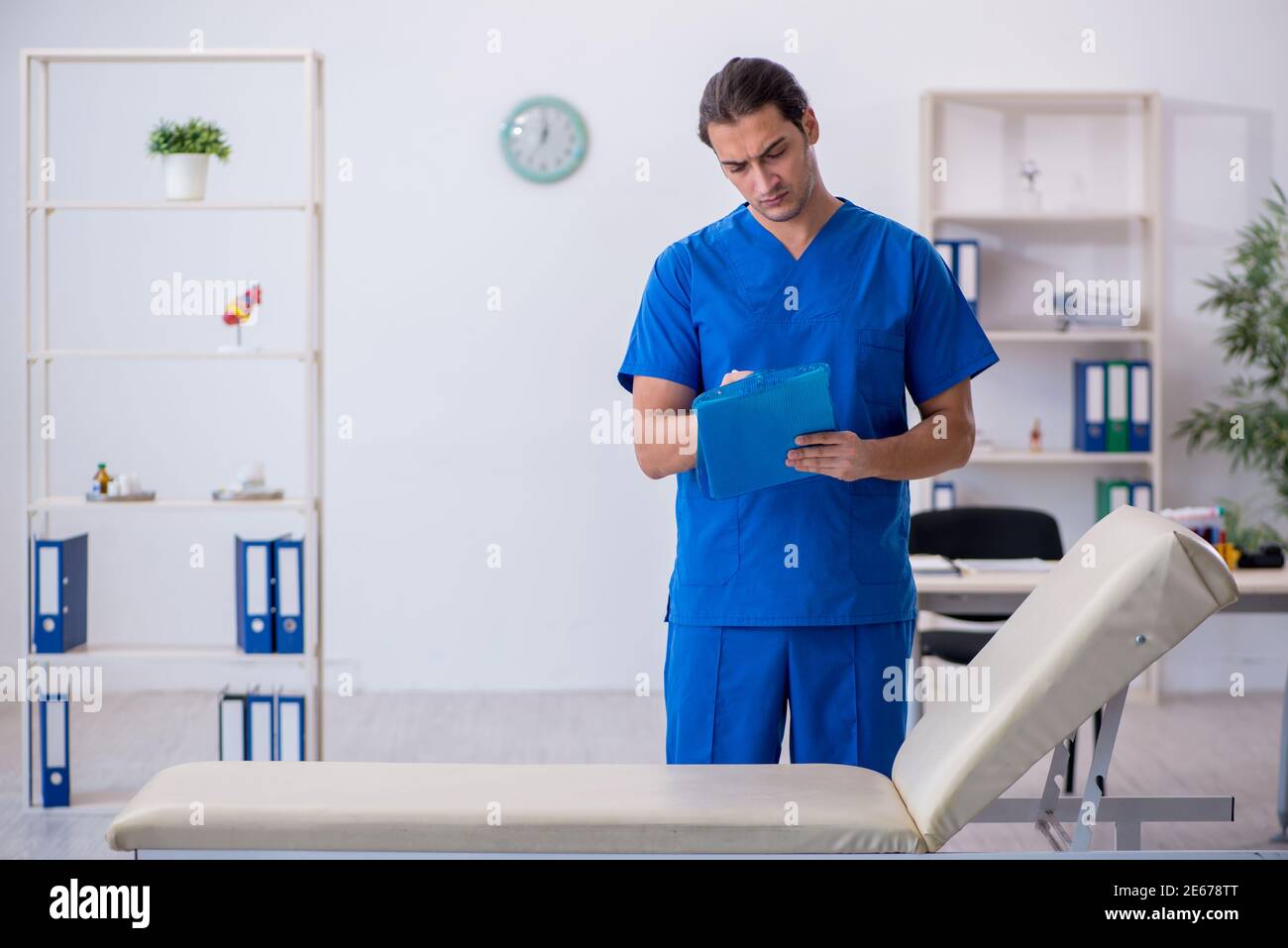 Young doctor taking notes at the hospital Stock Photo - Alamy