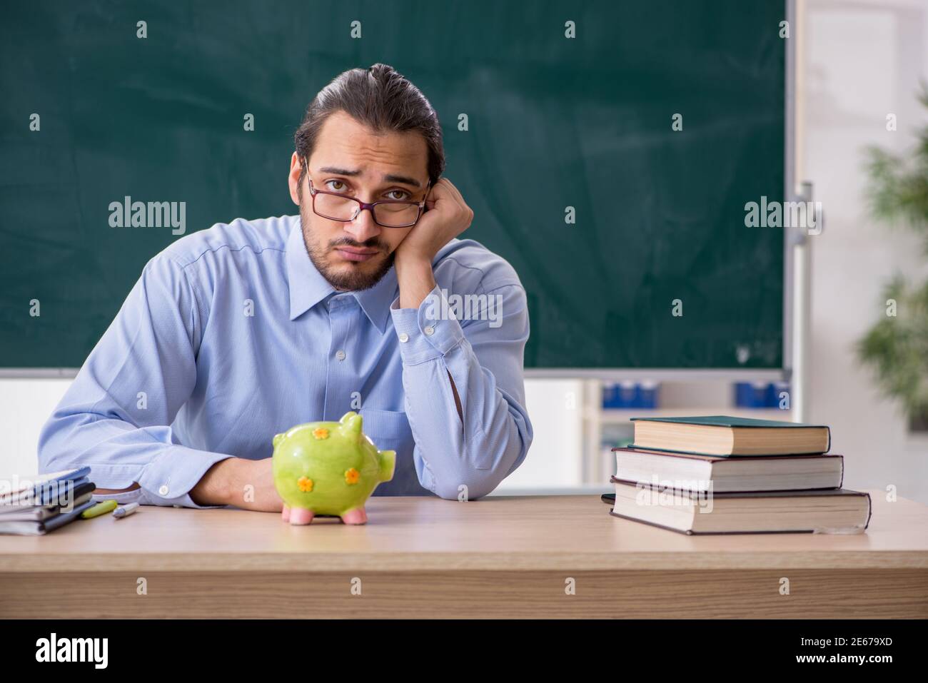 Young underpaid teacher in the classroom Stock Photo - Alamy