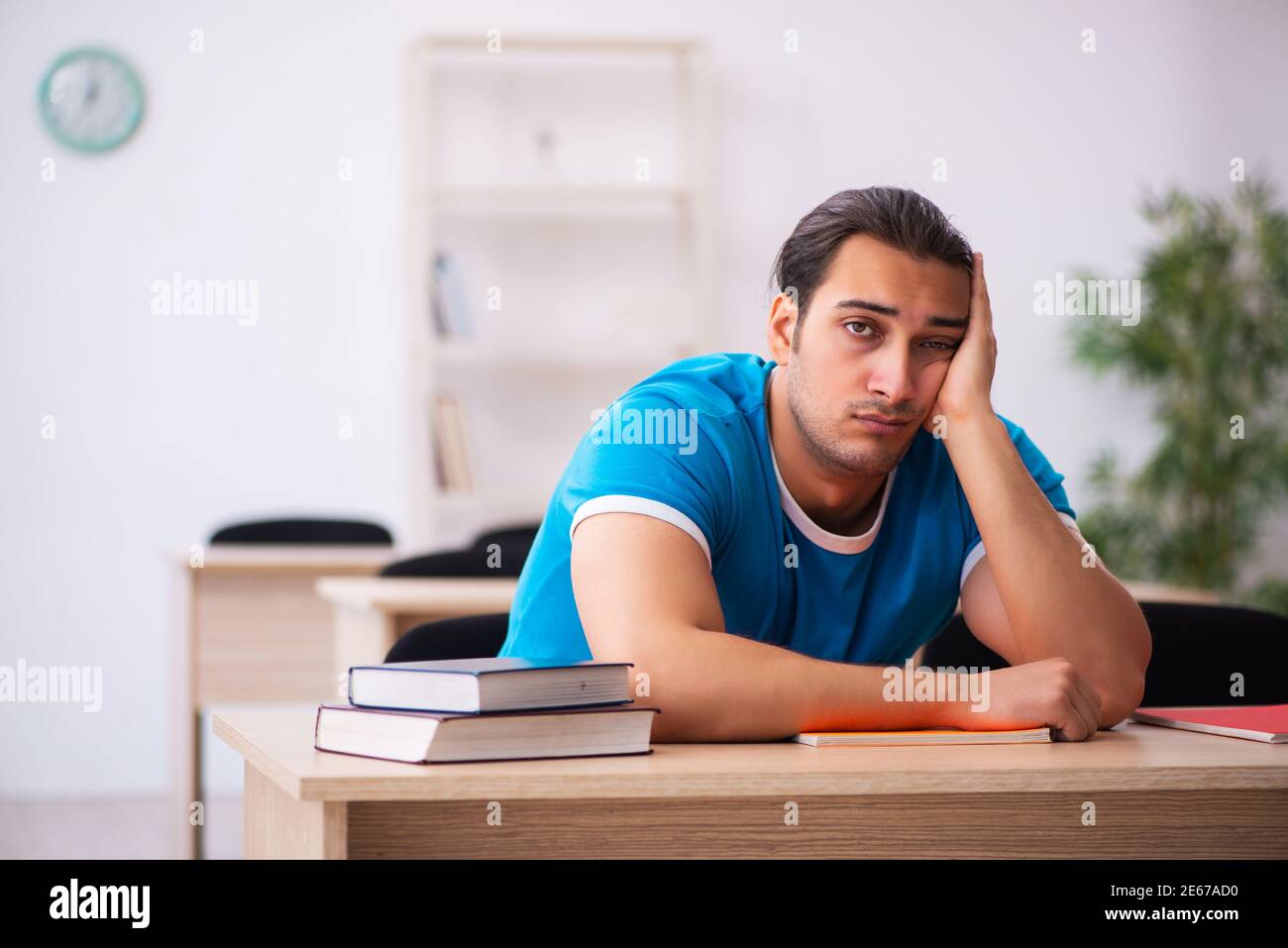 Exhausted student preparing for the exams in the classroom Stock Photo ...