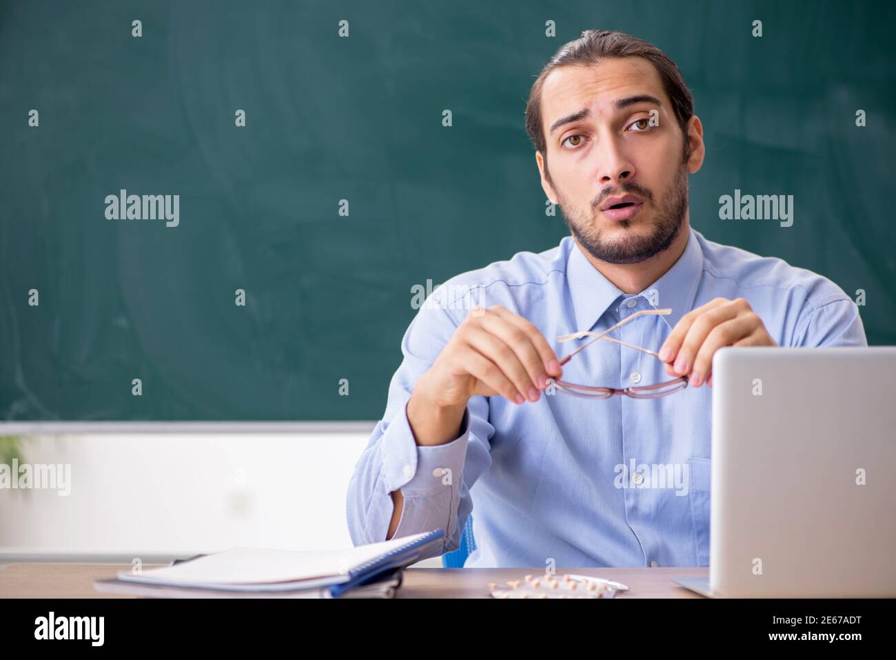Young sick teacher in the classroom Stock Photo - Alamy