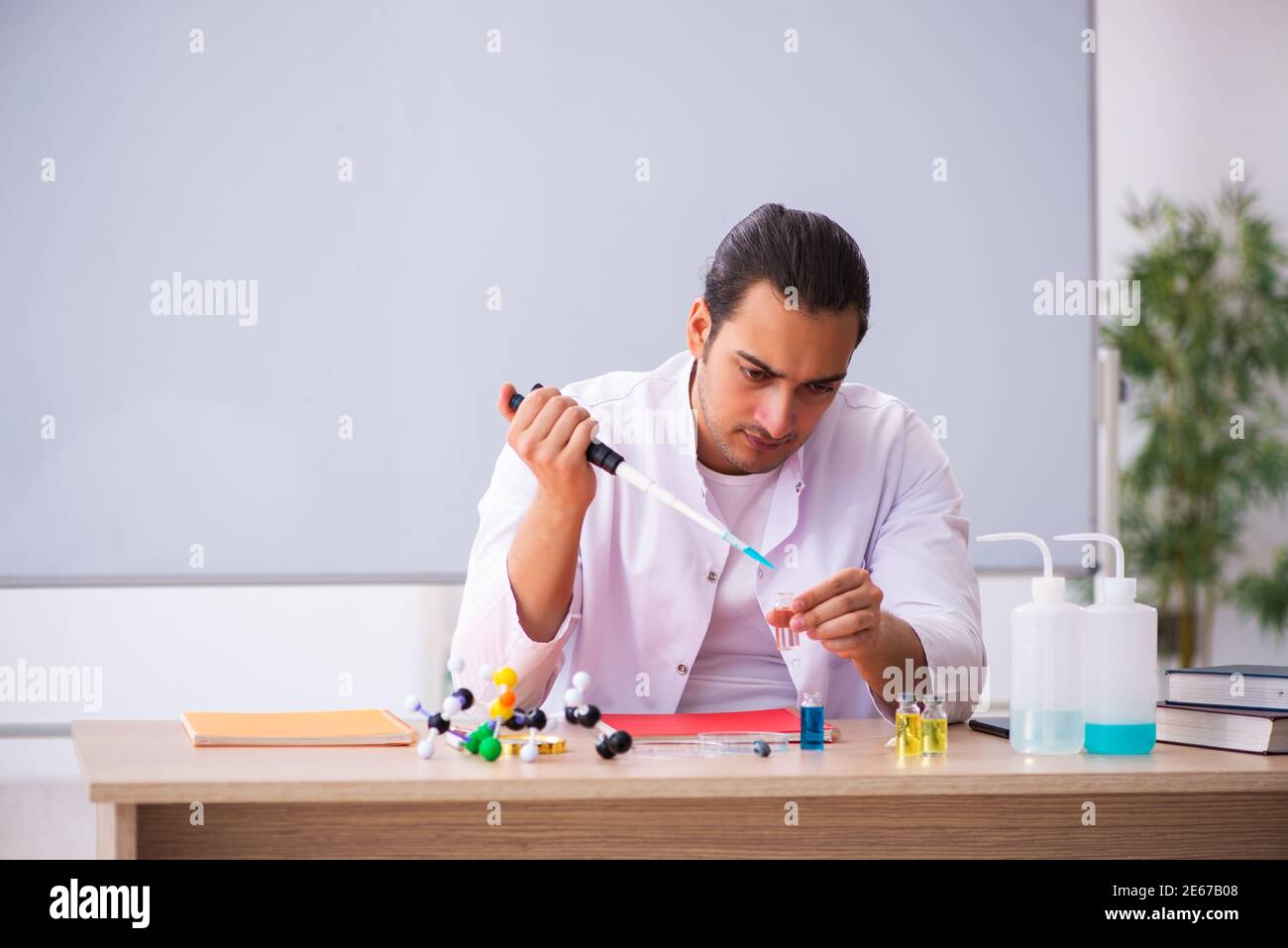 Young chemistry teacher in the classroom Stock Photo - Alamy