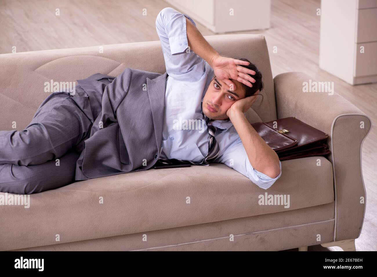 Tired businessman coming home after working day Stock Photo - Alamy