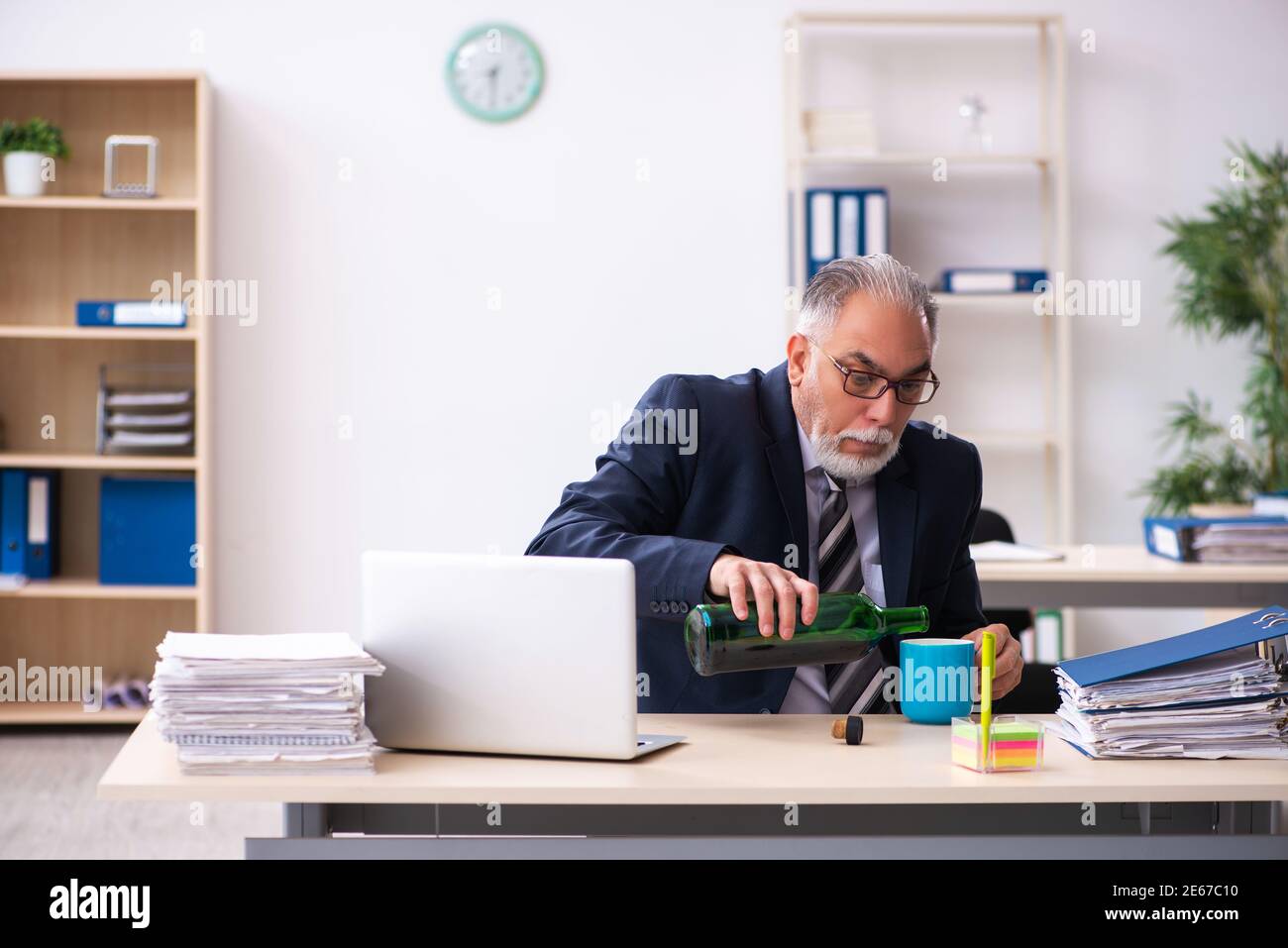 Old businessman drinking alcohol in the office Stock Photo - Alamy
