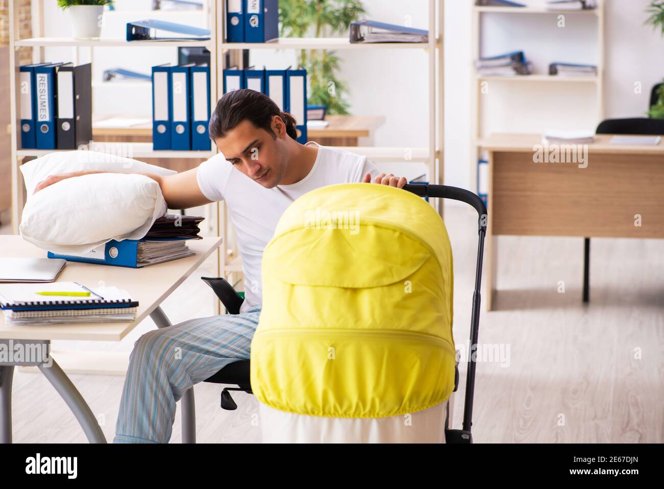 Young employee looking after newborn at workplace Stock Photo - Alamy