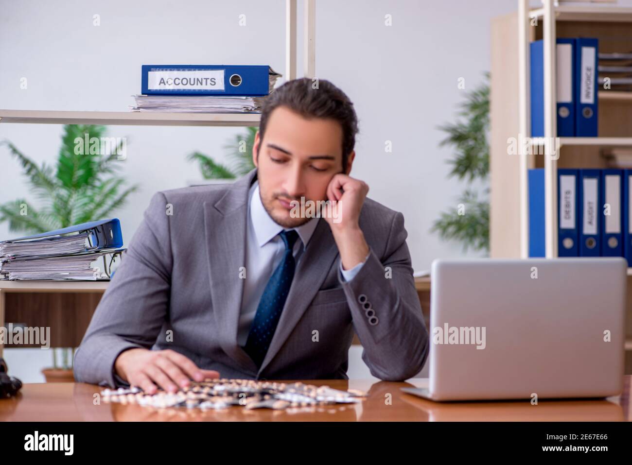 Male sick employee suffering at workplace Stock Photo - Alamy