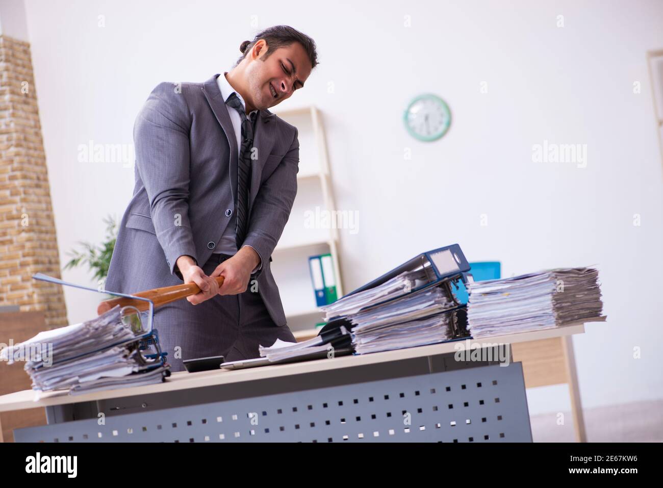 Male employee angry with excessive work holding baseball bat Stock ...