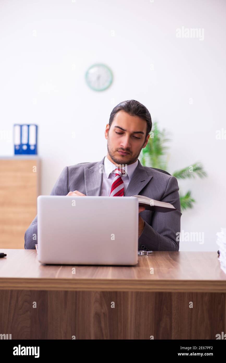 Male employee reading book in the office Stock Photo - Alamy